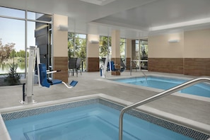 Área de piscina de hotel, com duas piscinas, equipamentos de ginástica e espreguiçadeiras.