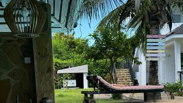 Um bar à beira da piscina com balcão de pedra, garrafas e uma bebida.