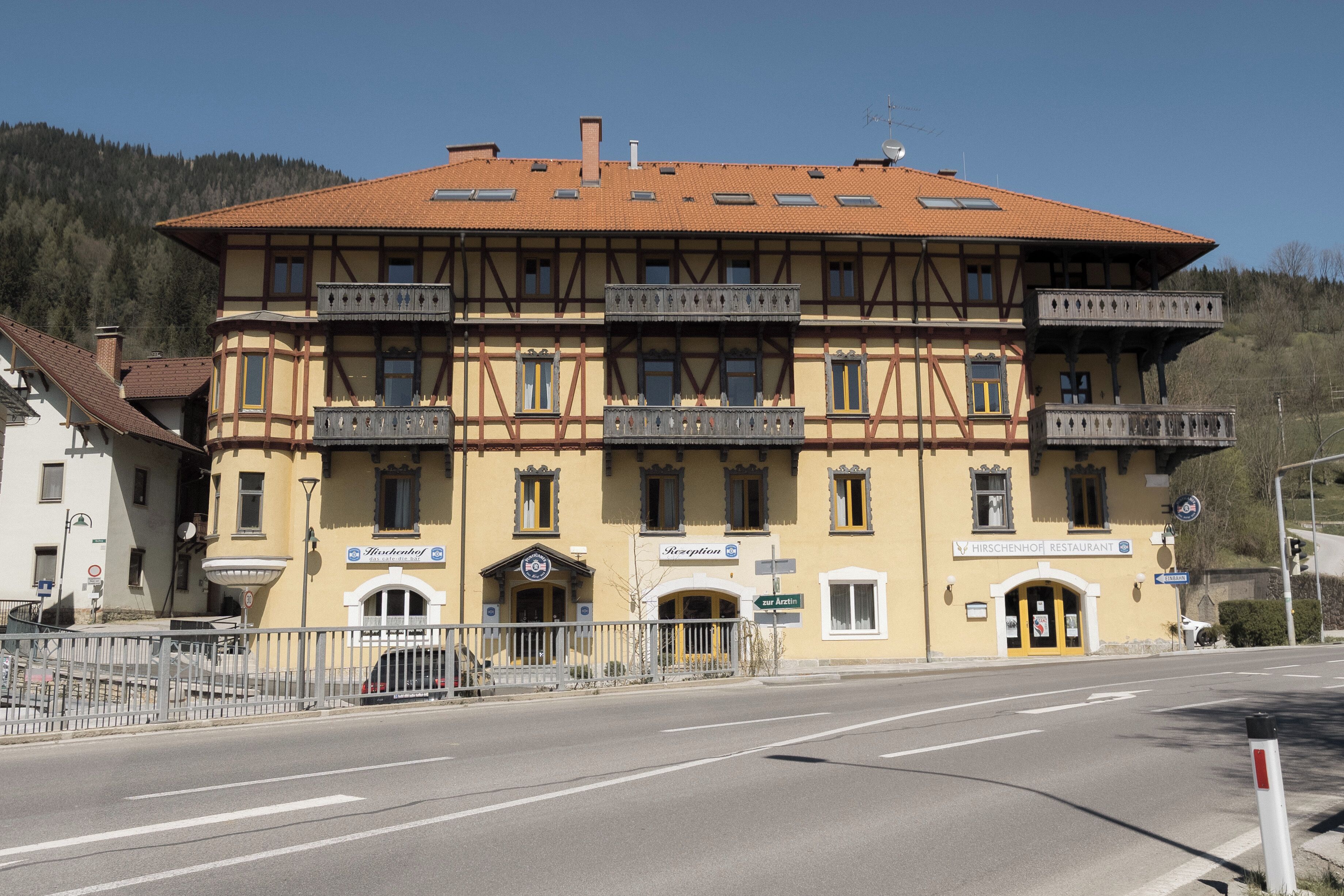 Um edifício de dois andares com fachada tradicional, área de recepção e placa indicando que é um restaurante.