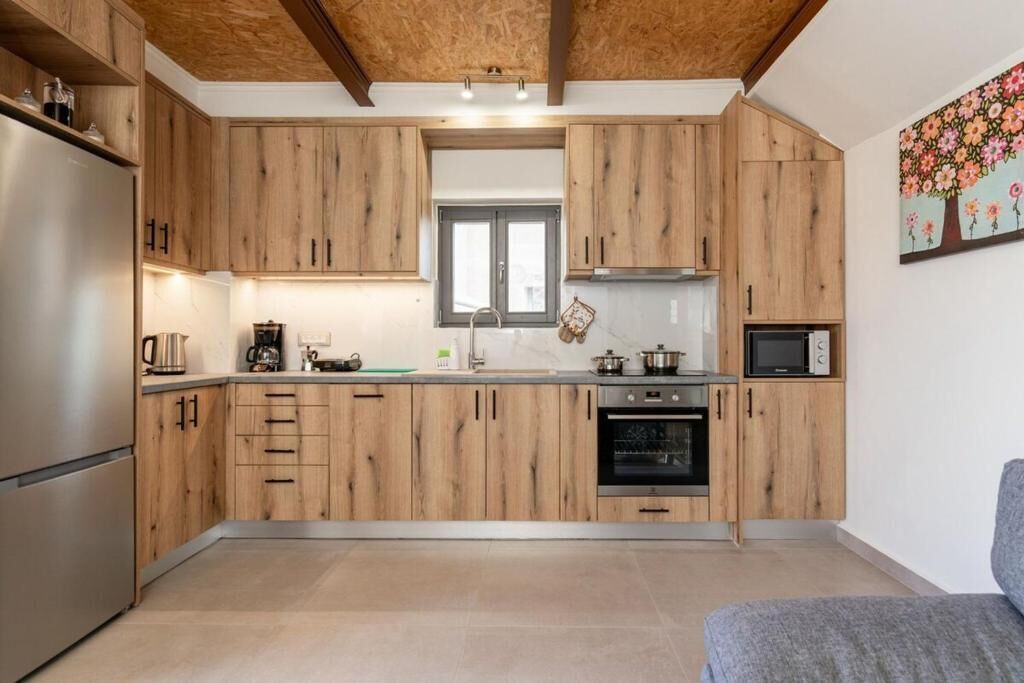 Cozinha moderna com armários de madeira, forno embutido e micro-ondas.