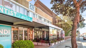 Um edifício com uma placa que diz '212 BONDI RD' e 'DENTIST'.