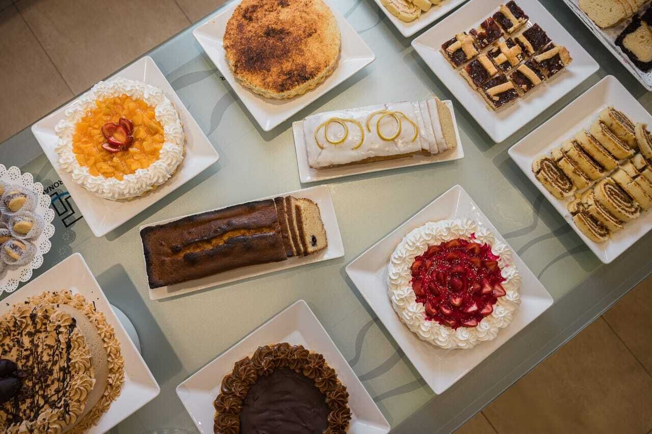 Diversos doces em pratos brancos.