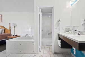 Suite Deluxe, 1 cama king-size, não fumadores, banheira de hidromassagem grande | Casa de banho | Uma combinação polibã/banheira, toalhas fornecidas, sabão, champô