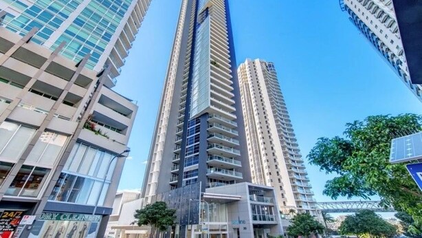 Um edifício alto com vários andares, janelas amplas e design arquitetônico moderno.