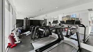 Uma academia moderna com esteiras, aparelhos de musculação e um espelho grande.