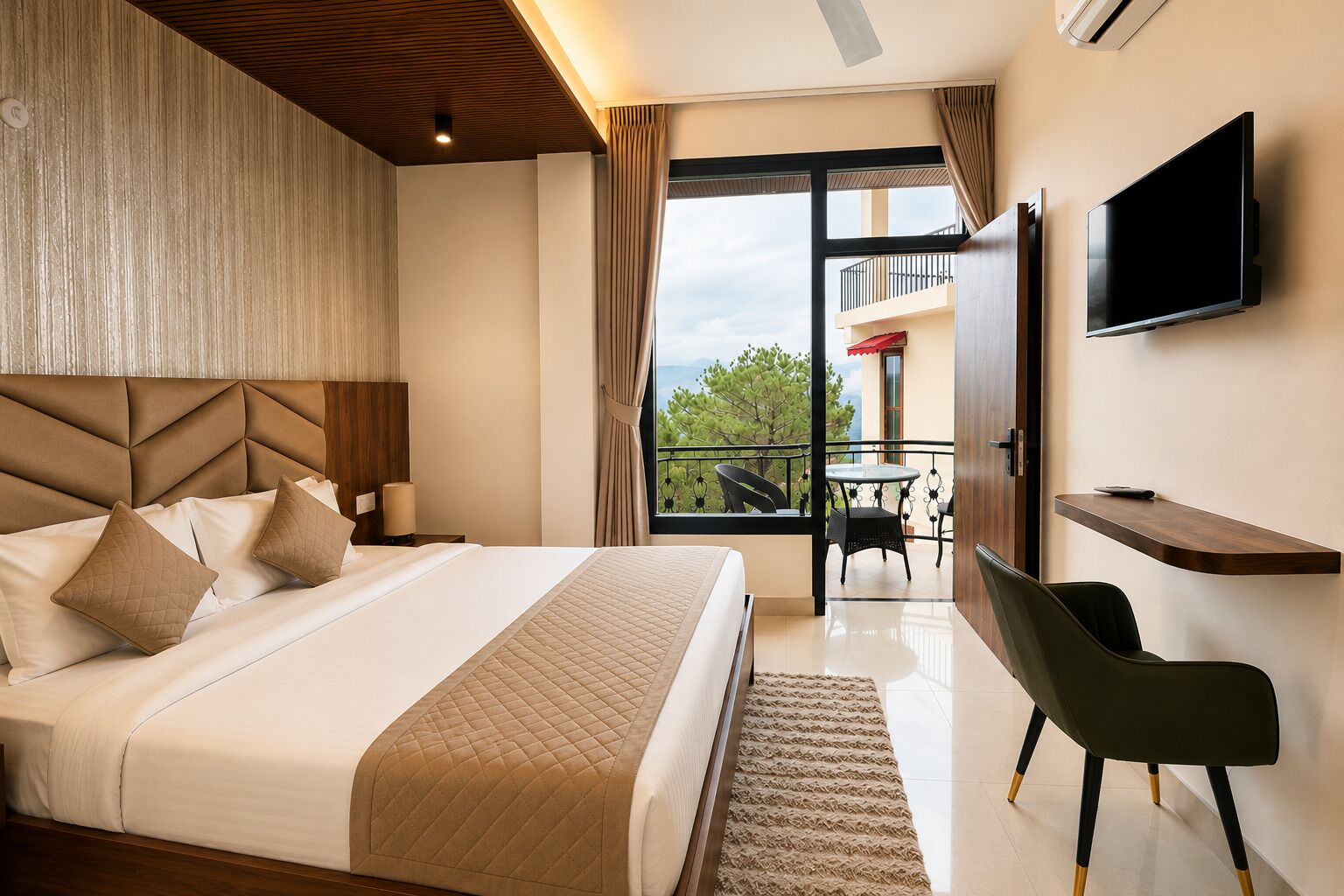 Quarto de hotel com uma cama grande, televisão, varanda com mesa e cadeiras e vista para o exterior.