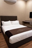 Quarto de hotel com cama, mesa de cabeceira, televisão de tela plana e aparelho de ar condicionado.