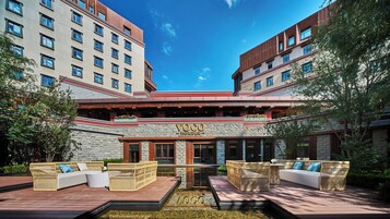 Um hotel com fachada de pedra, área de estar ao ar livre e céu claro.