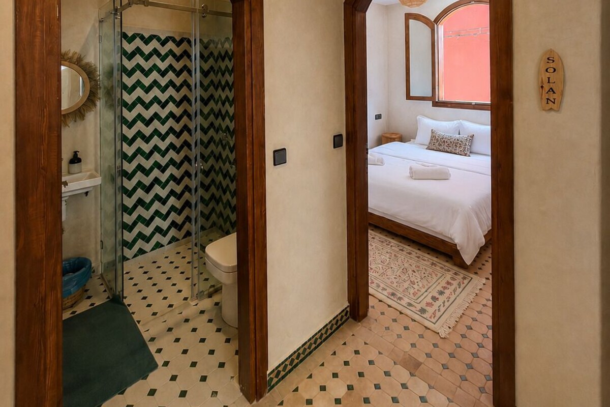 Quarto de hotel com chuveiro, uma cama e vista para o exterior.