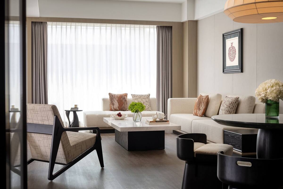 Uma sala de estar moderna com um sofá, poltronas, uma mesa de centro e uma mesa de jantar.