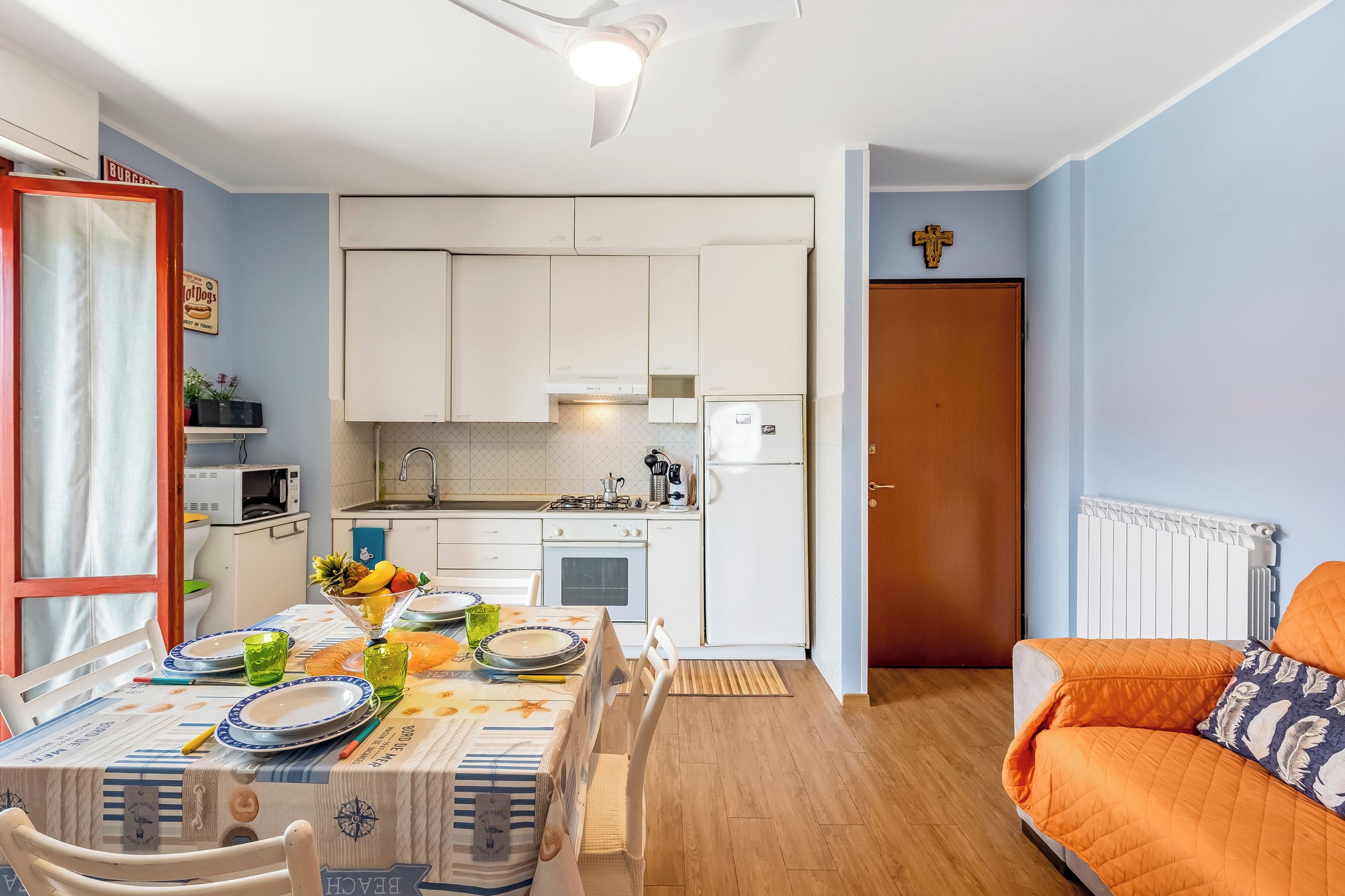 Um espaço compacto para viver, com área de refeições, cozinha compacta e sofá.