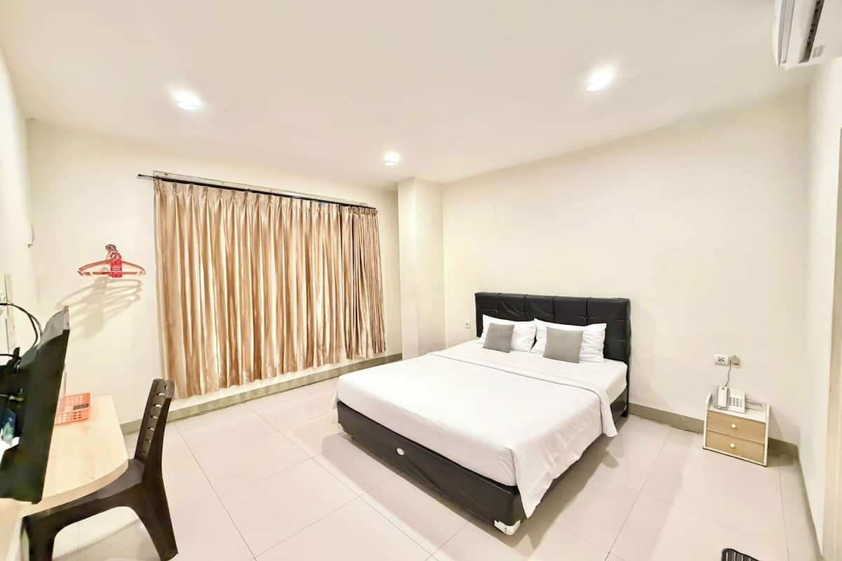 Quarto com cama, escrivaninha, cadeira, guarda-roupa e cortina.