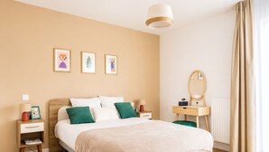 Quarto com cama, mesas de cabeceira, cômoda, espelho e quadros na parede.