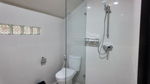 Um banheiro moderno com chuveiro em gabinete de vidro, vaso sanitário e secador de mãos.