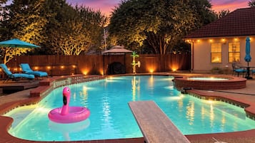 Piscina com hidromassagem, espreguiçadeiras e área de estar ao ar livre.