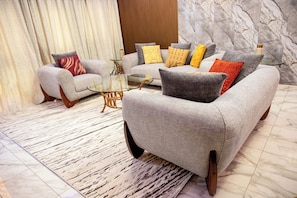 Uma sala de estar moderna com sofá, mesa de centro e almofadas decorativas.