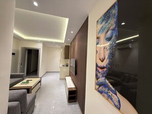 Um interior moderno com sofá, mesa de centro, pintura e área de cozinha.