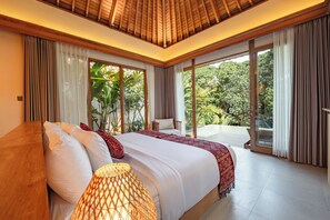Quarto com cama grande, cabeceira de madeira e vista para vegetação exuberante.