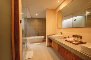 Uma casa de banho moderna com uma banheira independente, um espelho grande e um lavatório com um cesto de toalhas.