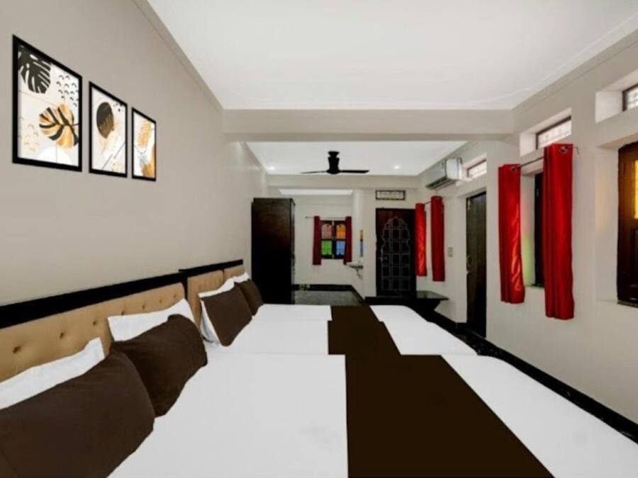 Quarto de hotel com uma cama grande, cabeceira e ventilador de teto.