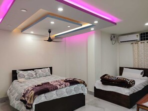 Quarto com duas camas, ventoinha no teto, iluminação embutida e ar condicionado.