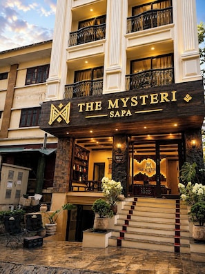 Entrada de um hotel com uma placa indicando 'The Mysterii Sapa'.