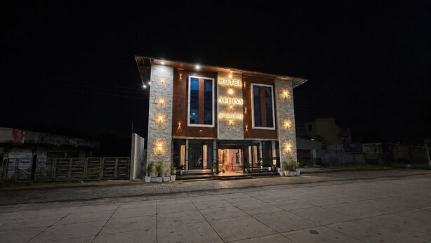 Um hotel moderno com estrutura em dois andares, grandes janelas e entrada bem iluminada.