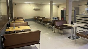Um restaurante com cabines e mesas, ventiladores de teto e um ar condicionado.
