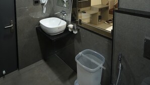 Casa de banho moderna com um espelho grande, uma pia, chuveiro e secador de cabelo.