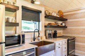 Cozinha moderna com micro-ondas, máquina de café e forno embutidos.