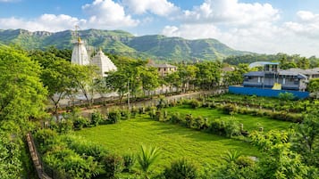 Paisagem verdejante com um templo, um rio e uma área residencial com casas.
