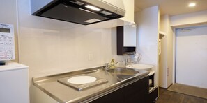 Cozinha moderna com eletrodomésticos de aço inoxidável, forno embutido e pia dupla.