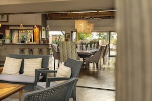 Decoração moderna com móveis de vime, área de bar e grandes janelas com vista.
