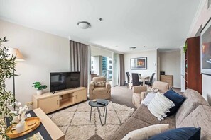 Uma sala de estar moderna com televis ão, sofá e mesa de centro.