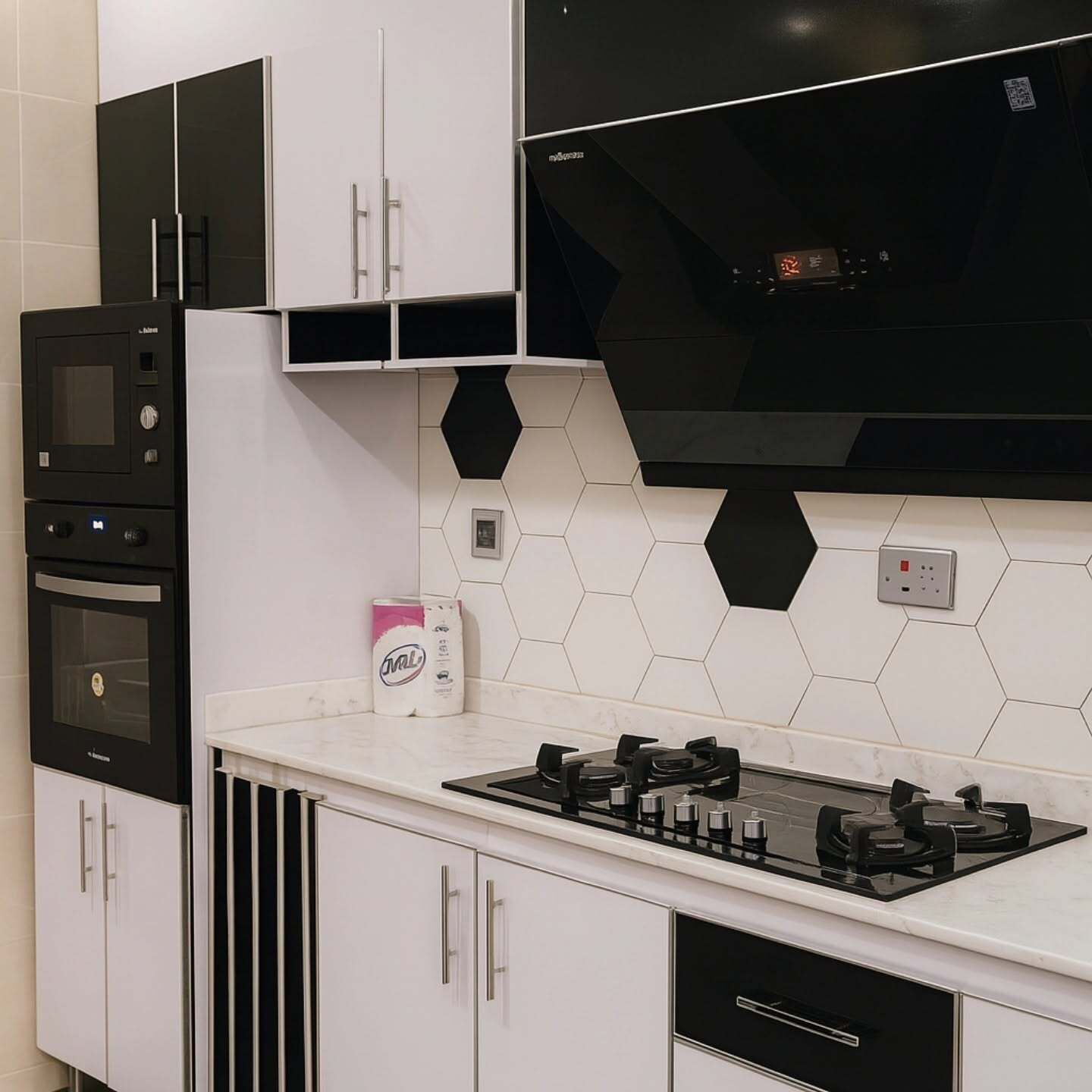 Cozinha moderna com fogão a gás, forno, micro-ondas e armários pretos.