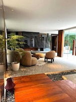 Uma sala de estar moderna com lareira, assentos confortáveis e uma janela grande.