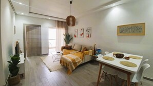 Uma sala de estar moderna com sofá, mesa de jantar e obras de arte nas paredes.