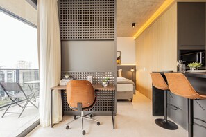 Cozinha moderna com área de jantar, espaço de trabalho com cadeira e vista para a cidade.