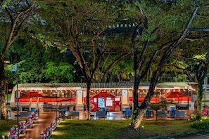 Restaurante com área externa, espaço coberto e um edifício ao fundo.