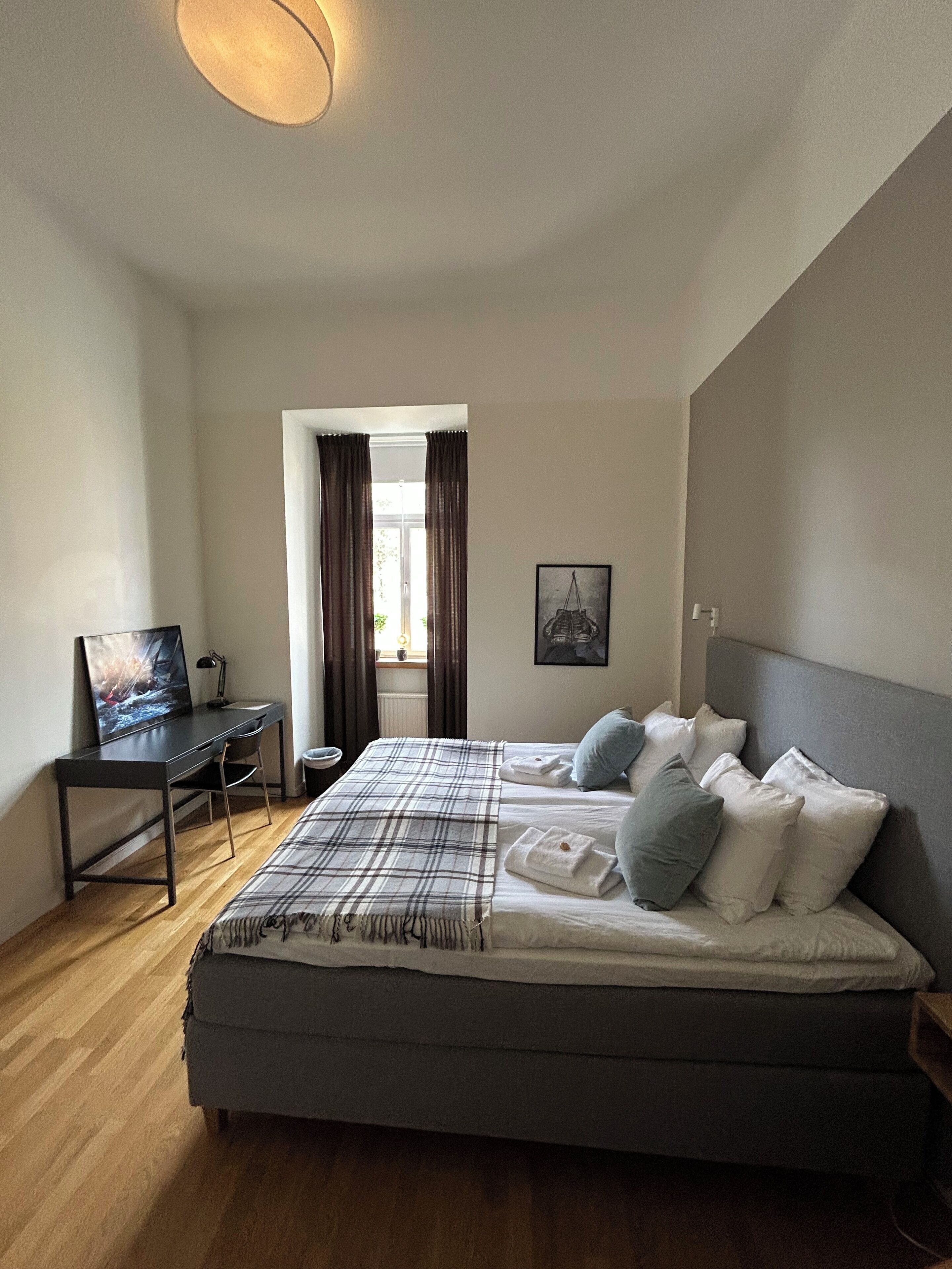 Um quarto com uma cama, uma escrivaninha e uma cadeira.