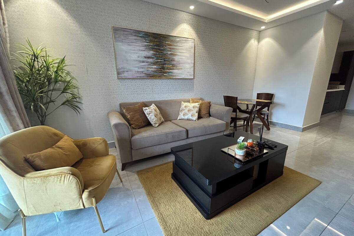 Uma sala de estar moderna com sofá, mesa de centro e cadeiras.