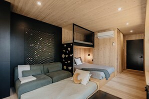 Quarto moderno com sofá, cama, luminária na parede e teto de madeira.