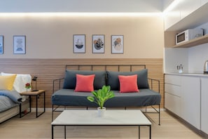 Uma sala de estar moderna com um sofá, uma mesa de centro e um vaso de planta.
