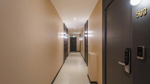 Corredor de hotel com portas numeradas 503, uma luminária e uma porta com leitor de cartão.