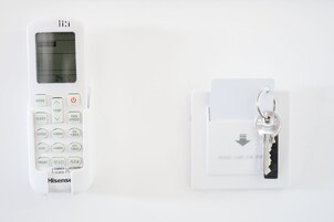 Um relógio digital branco da Hisense, com entrada para cartão-chave e um cartão inserido.