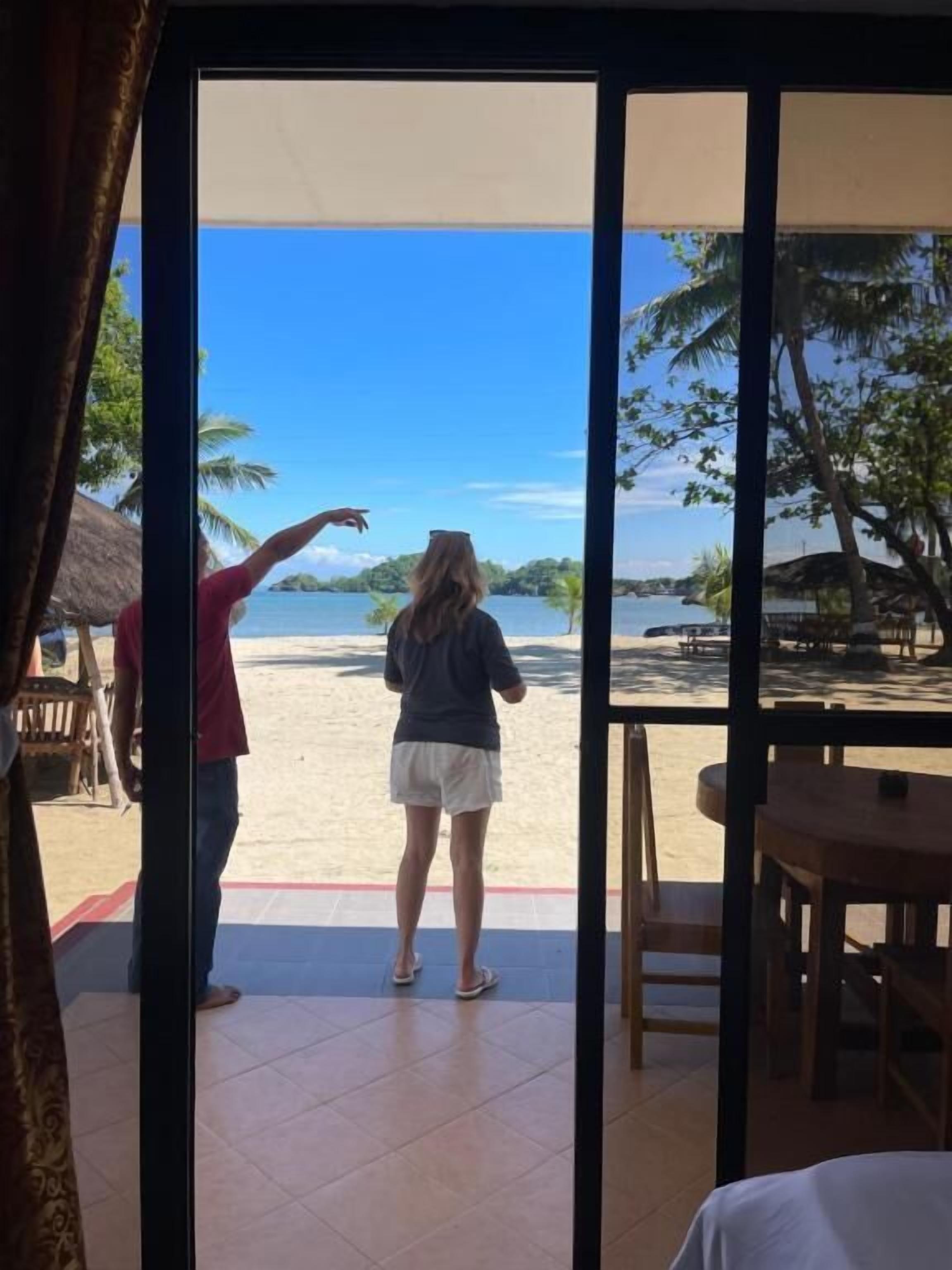 Quarto com vista para a praia, uma mesa e uma cadeira.