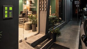 Residência boutique com entrada de vidro, balcão de recepção e um carro estacionado na frente.