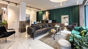 Uma sala de estar moderna com sofá, poltronas, mesa de centro e balcão de recepção.