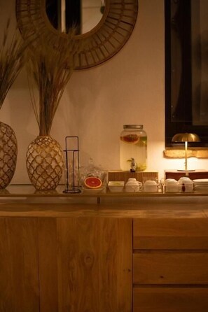 Um balcão de madeira com vasos decorativos, um espelho e uma lâmpada.