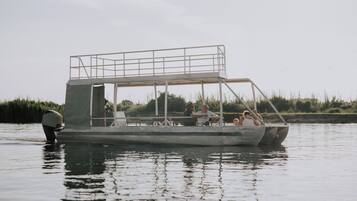 Um barco com convés superior coberto e área de estar aberta.